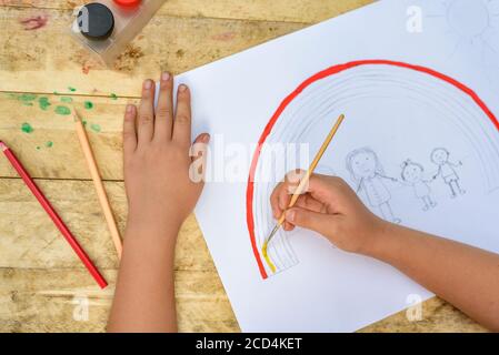 Hands of a family drawing with pencil and paints. Top view to white ...