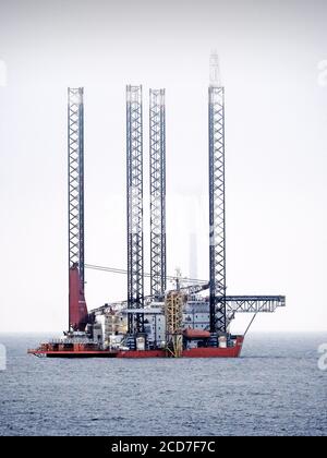 Jack up rig GMS Endeavour and a wind turbine in the North sea in clear ...
