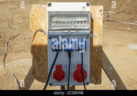 Industrial sockets and plug on distribution board. Construction site electricity, temporary ...