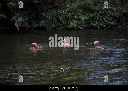 Hackney marshes on a hot August afternoon. People swim in the River Lea ...