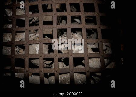 Human skulls and bones are stacked on top of each other. The grave ...