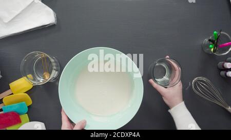 Step by step. Flat lay. Pouring royal icing into the piping bag to ...