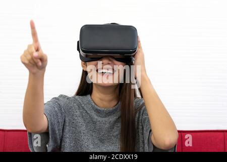 Asian woman playing VR gaming with virtual reality headset and ...