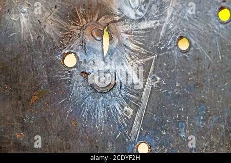 Bullet holes on chunk of metal after testing strength of armor with ...