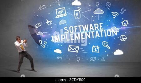 Businessman defending with umbrella from SOFTWARE IMPLEMENTATION ...