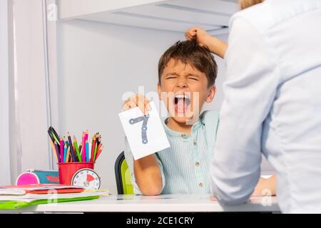 Autistic child tear hairs and scream expressing negative emotions while ...