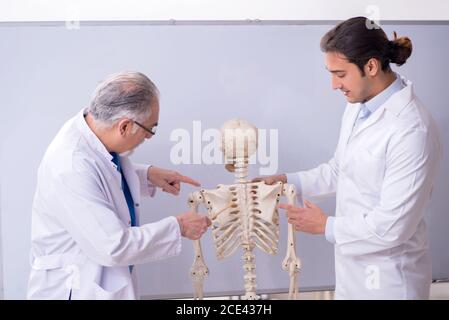 Experienced doctor surgeon teaching young assistant Stock Photo - Alamy
