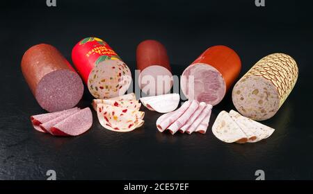 Traditional German cold cuts sausages as closeup on a black board with ...