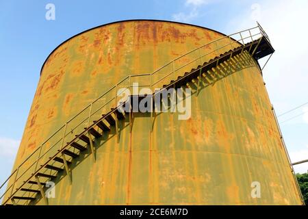 A large rusting storage tank at a vintage industrial facility Stock ...