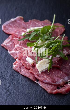 Fresh carpaccio with rocket on slate Stock Photo - Alamy