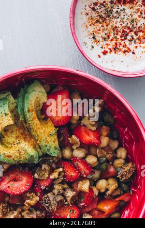 Top view composition of crop anonymous person breaking eggs into bowl ...