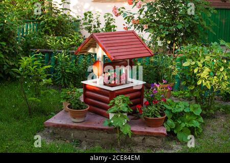 A small decorative well with a lot of color near it in the village yard ...