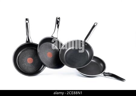 Modern frying pans above ground in studio Stock Photo - Alamy
