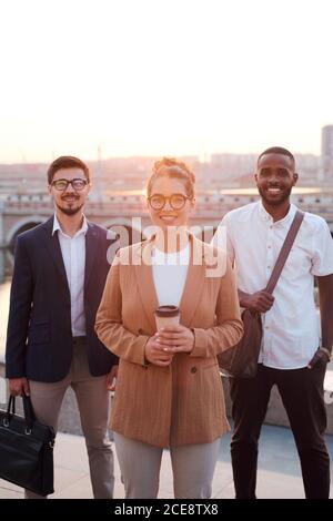 Cheerful interracial business people holding glasses of champagne and ...