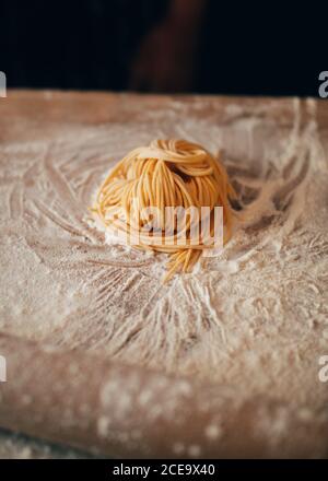 Tangled spaghetti on table with flour Stock Photo - Alamy