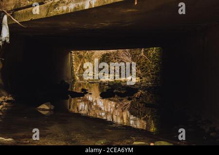 A Shallow Creek Flowing Under a Concrete Bridge Surrounded by Rocks ...