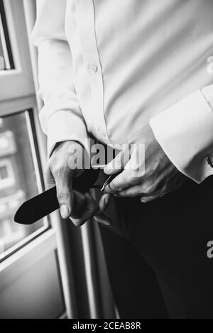 man buttoning belt on pants Stock Photo - Alamy