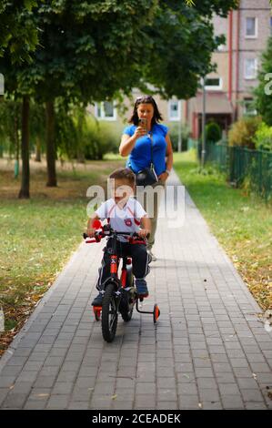 Small boy riding bicycle outside child rides bike wearing helmet Stock ...