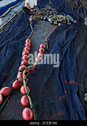 A fishing net is placed on the ground with its yellow buoys Stock Photo ...