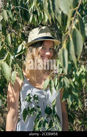 Beautiful young woman in hat and gray sweater meditates with folded ...