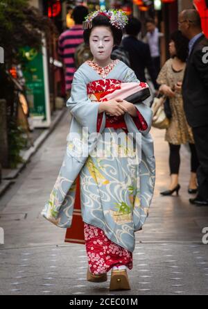 young pretty geisha in kimono with sakura and decoration on black ...