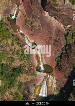 Multi-step waterfalls with plunge pools in a landscape of red rock ...