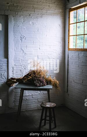 Concept of bouquet of dry coniferous twigs in craft paper on table near ...