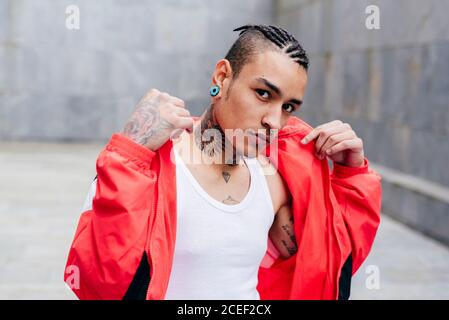 Young hispanic man with tattoos holding tron cryptocurrency coin ...