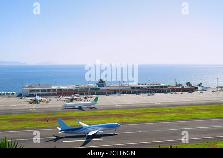 Aerial view of Funchal international airport with planes by terminal ...