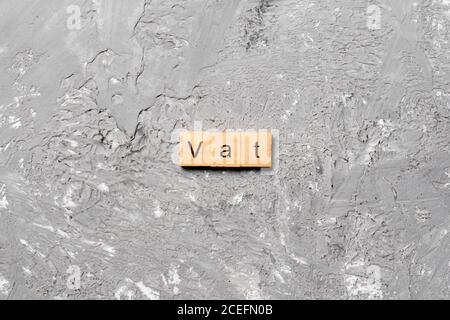 VAT word written on wood cubes on the background of various banknotes ...
