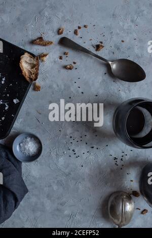 crumbs of fresh bread and metal spoon lying on plaster surface Stock ...