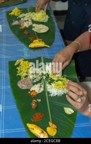 Traditional Kerala food being eaten on a banana leaf during the Onam ...