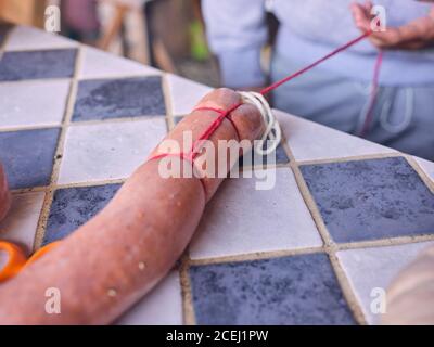 Crop senior person sewing animal bowl with meat while sitting at table ...
