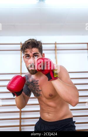 Young man athlete boxing workout in fitness gym on dark background ...