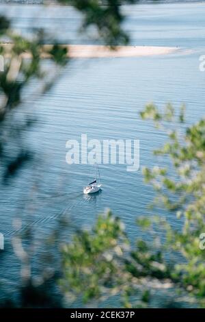 Modern yacht floating on rippling sea water against gray overcast sky ...
