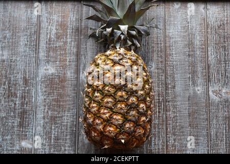 BANYAN KEY: A single pineapple sits in a flat lay on a wooden cutting ...