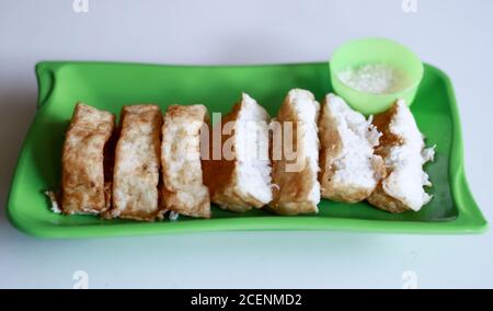 Pancong cake or kue pancong and sugar on wood background. Street food ...
