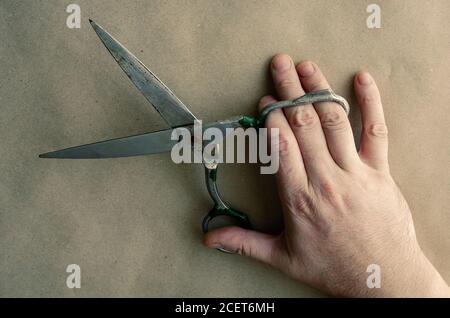 Hand holds old dirty scissors on green background Stock Photo - Alamy