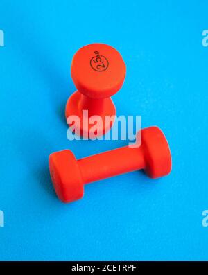 Two red weights 2,5 kg on the blue background Stock Photo - Alamy
