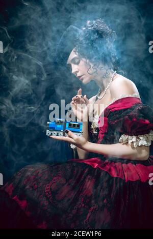Train model. Young woman as Anna Karenina isolated on dark blue ...