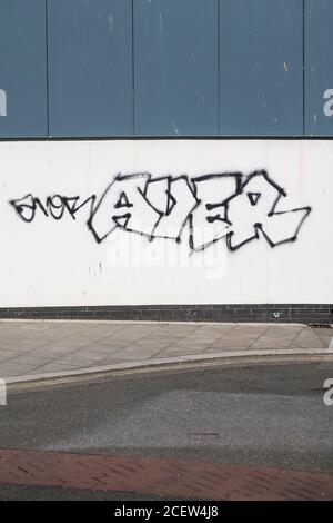 Ugly graffiti and tags sprayed on a wall in Newquay town centre center ...
