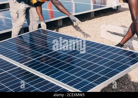 Busy black male engineers installing solar batteries in construction ...
