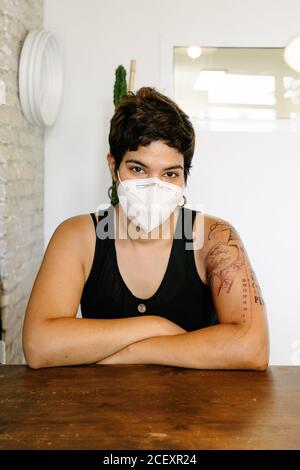 Delighted female in protective mask during coronavirus looking at ...