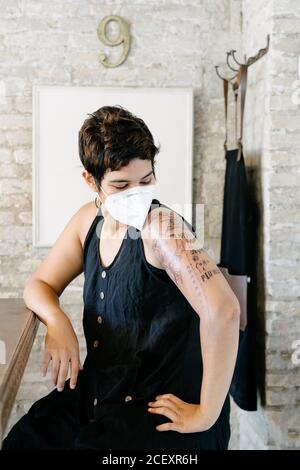 Delighted female in protective mask during coronavirus looking at ...