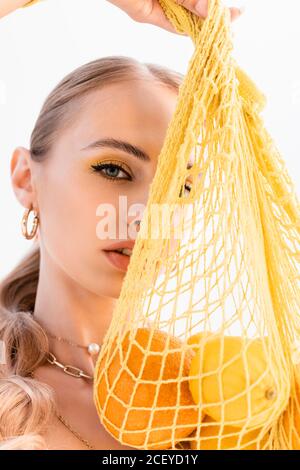 String bag with oranges and lemons on red background, top view Stock ...