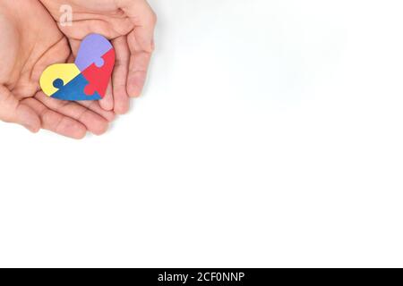 Child hands holding colorful paper heart over multicolored paper ...