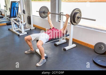 Young dutch man bench press with barbell in fitness room Stock Photo ...