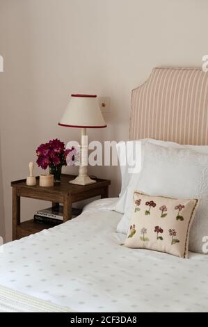 White bedroom bright interiors with bed and flowers Stock Photo - Alamy