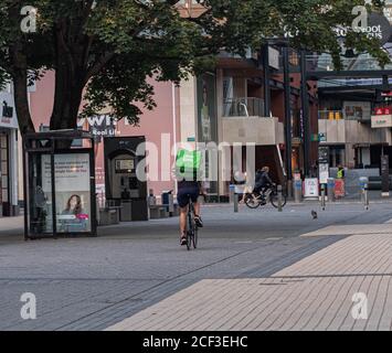 A Deliveroo takeaway bicycle rider with food delivery thermal bag in ...