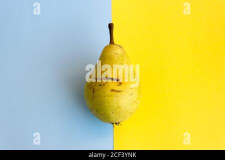 Ugly yellow apple on a blue background. Funny, unnormal fruit or food ...